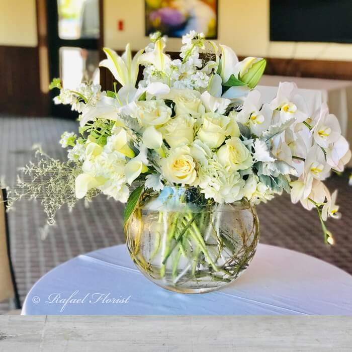 White floral design of phalaenopsis orchids, white calla lilies and roses